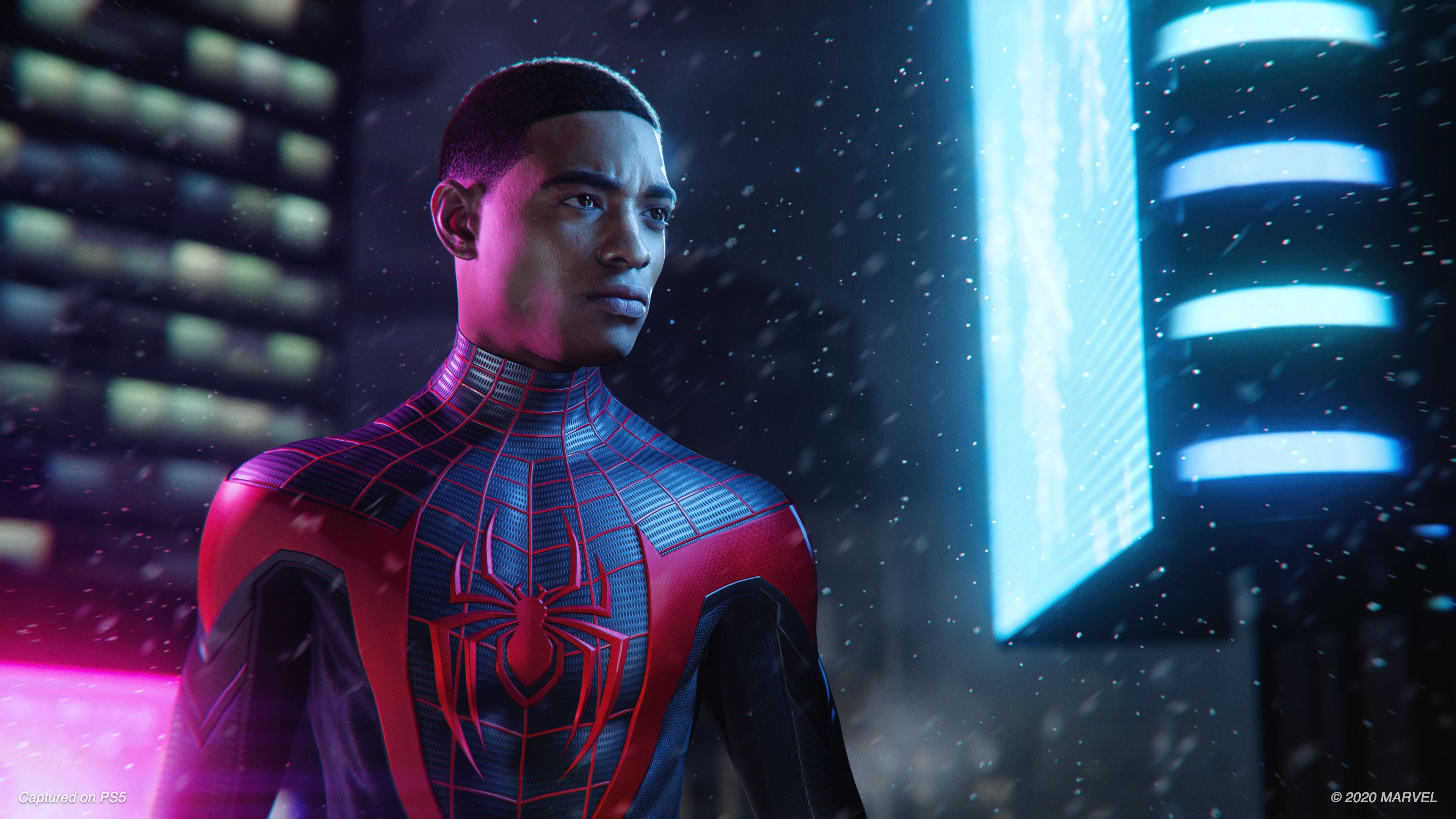 An unmasked Miles Morales wearing the Spider-Man suit in Spider-Man: Miles Morales